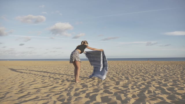 A girl spreading out a towel on the beach - Free Stock Video Footage ...
